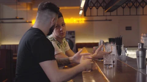 Two adult men sitting at the bar counter... | Stock Video | Pond5