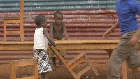 Two African kids climbing on the table | Stock Video | Pond5