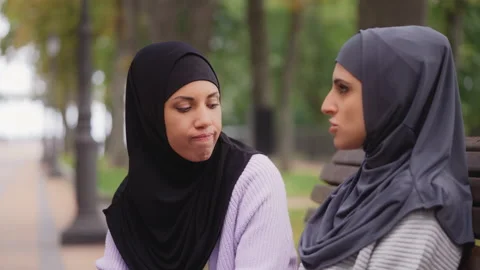 Two arab women in hijabs talking in park... | Stock Video | Pond5
