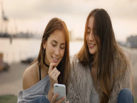Two beautiful girls talking over some ph... | Stock Video | Pond5