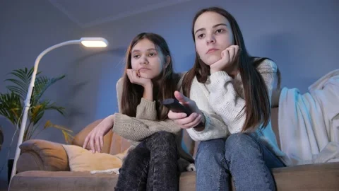 Two bored girls switching TV channels on... | Stock Video | Pond5