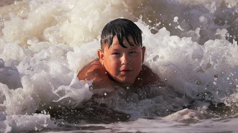 Two boys dive into a foaming wave. Live ... | Stock Video | Pond5