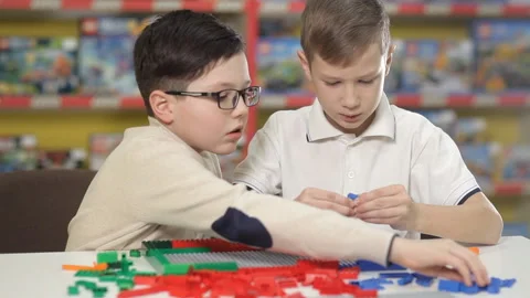 Two boys erect buildings from a children... | Stock Video | Pond5