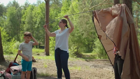 Two boys helping two moms to put up a te... | Stock Video | Pond5