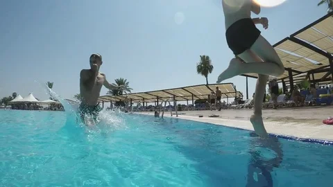 Two boys jump feet first while swirling... | Stock Video | Pond5