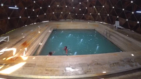 Two boys swim in the thermal bath under ... | Stock Video | Pond5