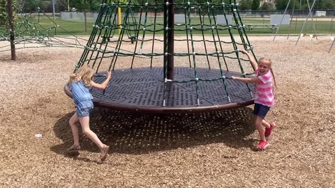 Two children spin and play at playground... | Stock Video | Pond5