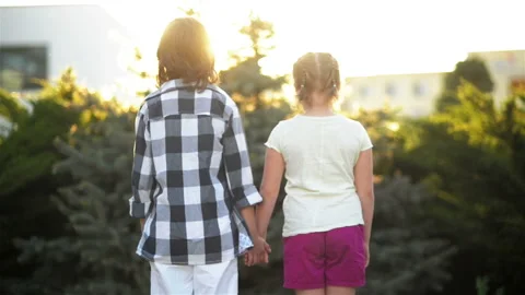 Two Children Stand Back And Hold Hands. ... | Stock Video | Pond5