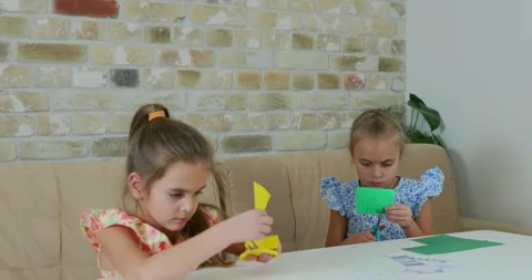 Two cute girls cut out with scissors fro... | Stock Video | Pond5