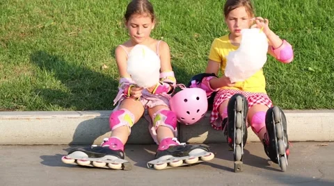 Two cute girls in roller skates sitting ... | Stock Video | Pond5