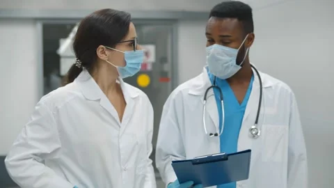 Two doctors in safety mask and gloves di... | Stock Video | Pond5