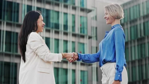 Two elegant business women shaking hands... | Stock Video | Pond5