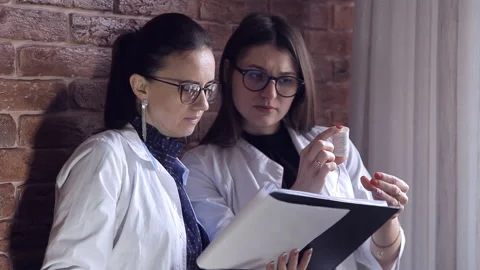 Two Female Doctors Look Through Medical ... | Stock Video | Pond5