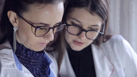 Two Female Doctors Look Through Medical ... | Stock Video | Pond5