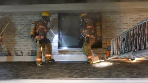 Two firefighters breaking window during ... | Stock Video | Pond5