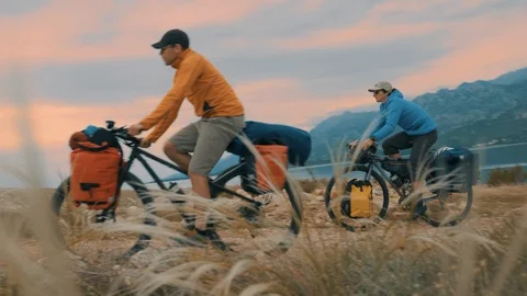 Two Friends Riding Bikes Next to the Sea | Stock Video | Pond5
