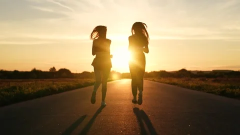 Two Best Friends Holding Hands In The Sunset