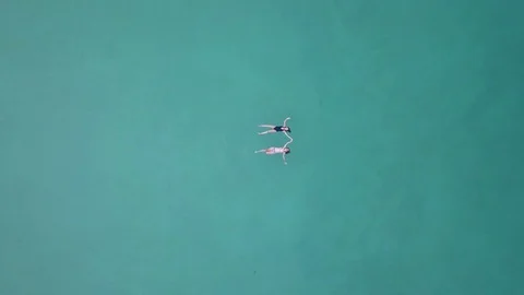 Two Girls Floating in Sea Holding Hands.... | Stock Video | Pond5