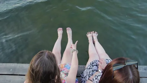 Two girls fun on pier slapping my feet o... | Stock Video | Pond5