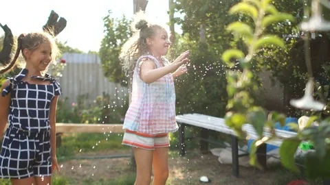 Two girls have fun jumping under the str... | Stock Video | Pond5