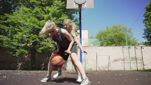 Two girls playing basketball on street c... | Stock Video | Pond5
