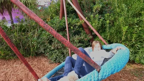 two girls riding on a large round swing ... | Stock Video | Pond5