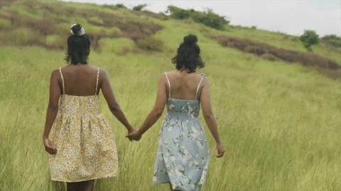 Two Girls walk into a distance while hol... | Stock Video | Pond5