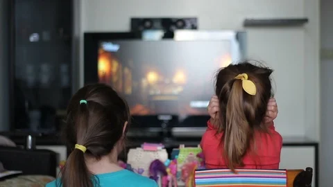 Two girls watching cartoon on television... | Stock Video | Pond5