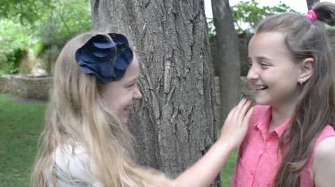 two girls whisper in the ear of a secret... | Stock Video | Pond5