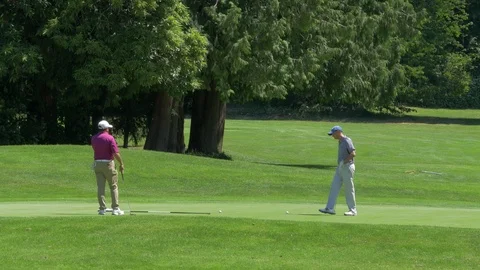 Two golfers putting green on golf course... | Stock Video | Pond5