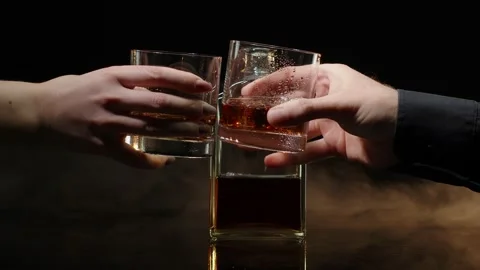 Two hands with glasses of cognac whiskey... | Stock Video | Pond5