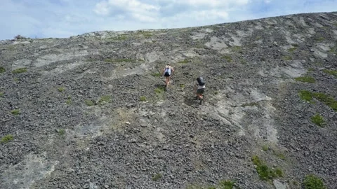 Two hikers climb rough scree slope on Ha... | Stock Video | Pond5