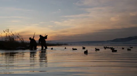 two hunters throwing duck decoys onto a ... | Stock Video | Pond5