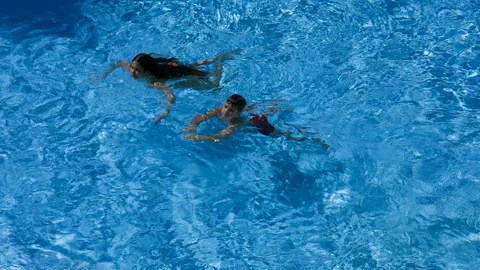 Two kids swim in pool together | Stock Video | Pond5