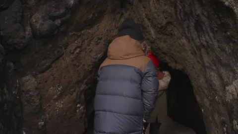 Two Kids Walking Into a Cave at the Beac... | Stock Video | Pond5