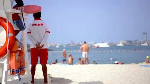 Two lifeguards are watching the beach. O... | Stock Video | Pond5