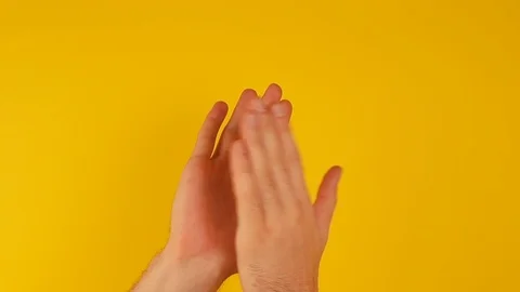 two male hands clapping on a yellow back... | Stock Video | Pond5