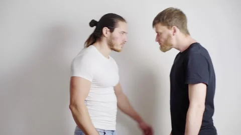 Two men are pushing, fighting, on a whit... | Stock Video | Pond5
