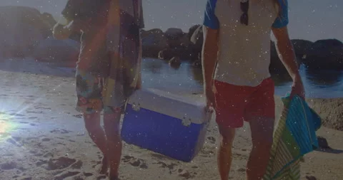 Two men walking across sand carrying blu... | Stock Video | Pond5