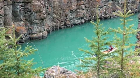 Two people in a canoe paddling upstream ... | Stock Video | Pond5