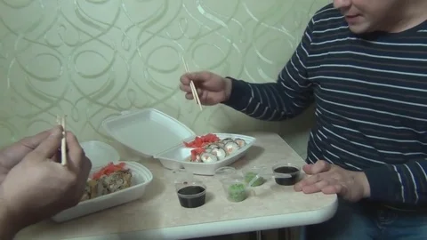 two people eating sushi, rolls, talking | Stock Video | Pond5