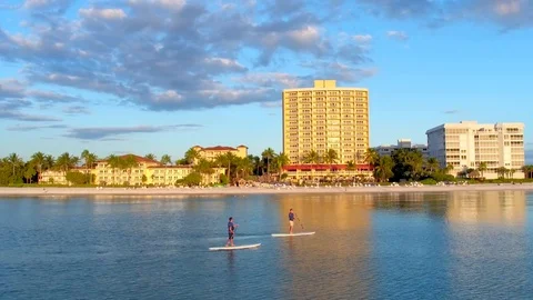 Two People Paddleboarding by Oceanfront ... | Stock Video | Pond5