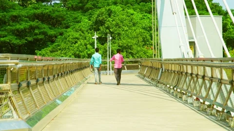 Two people walking on a bridge | Stock Video | Pond5