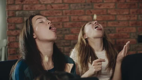 Two pretty girls throwing popcorn and tr... | Stock Video | Pond5