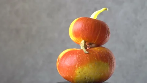 Two pumpkins spinning on a gray backgrou... | Stock Video | Pond5