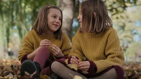 Two siblings sister sitting in the park ... | Stock Video | Pond5