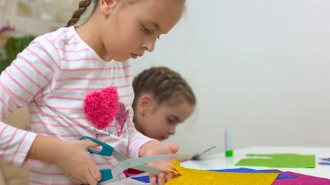 Two sisters cut out crafts from colored ... | Stock Video | Pond5