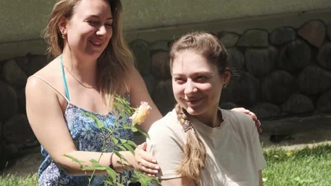 Two sisters on a sunny day in the garden... | Stock Video | Pond5