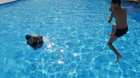 Two small boys jumping feet first in a s... | Stock Video | Pond5