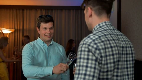 Two smiling guys speaking at party | Stock Video | Pond5